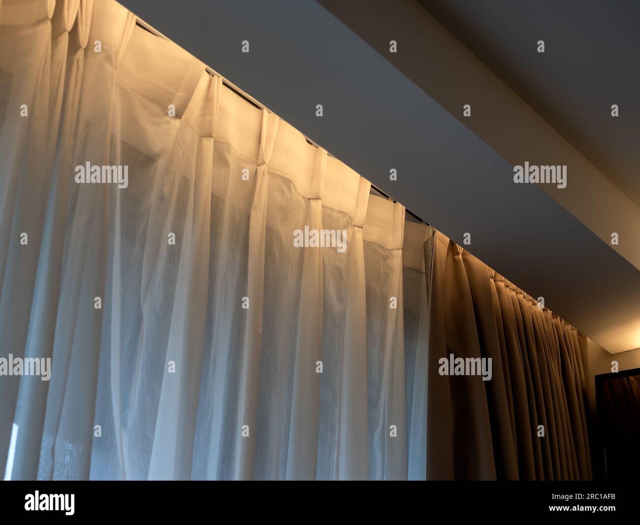 Beige blackout curtain and white translucent linen curtains on curtain ...