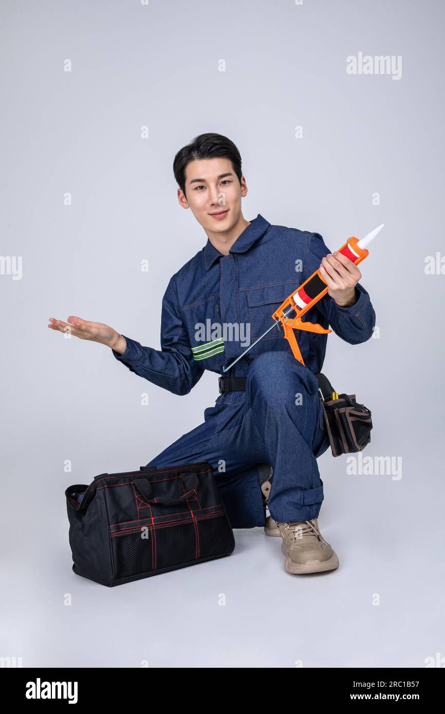 millennials and gen z, korean asian young man, site staff with caulking ...