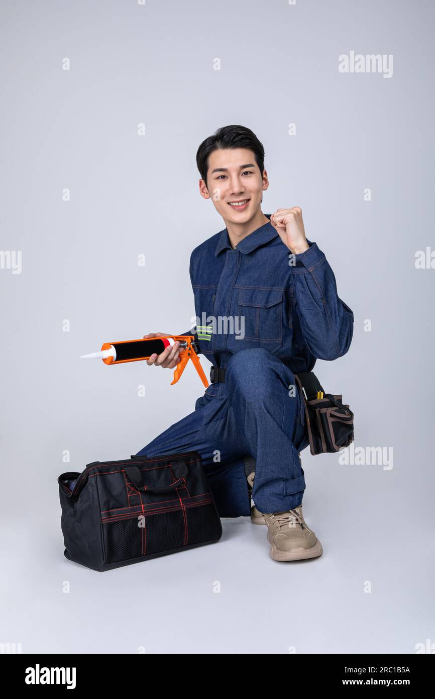 millennials and gen z, korean asian young man, site staff with caulking ...