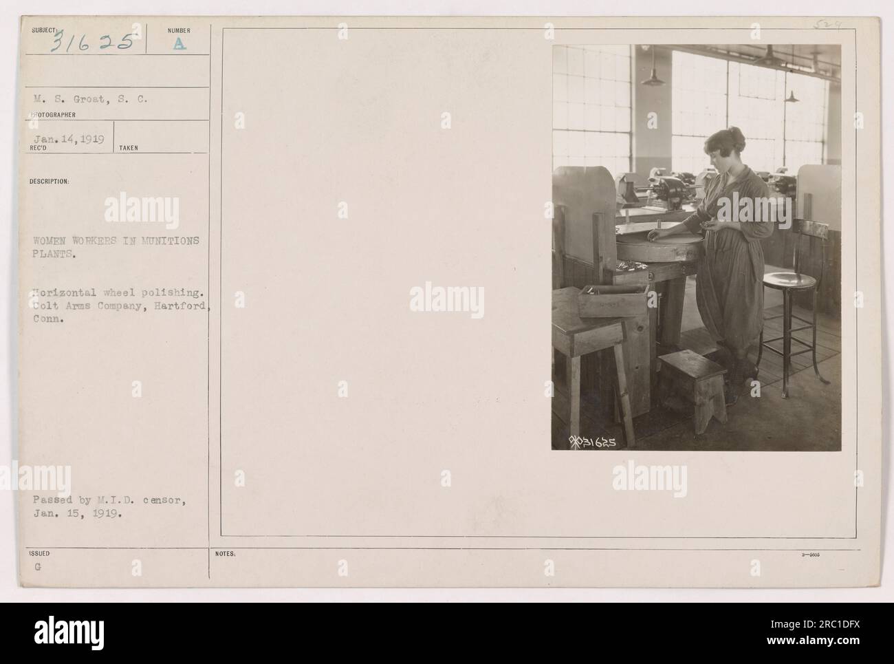 A group of women workers in a munitions plant are seen engaged in ...