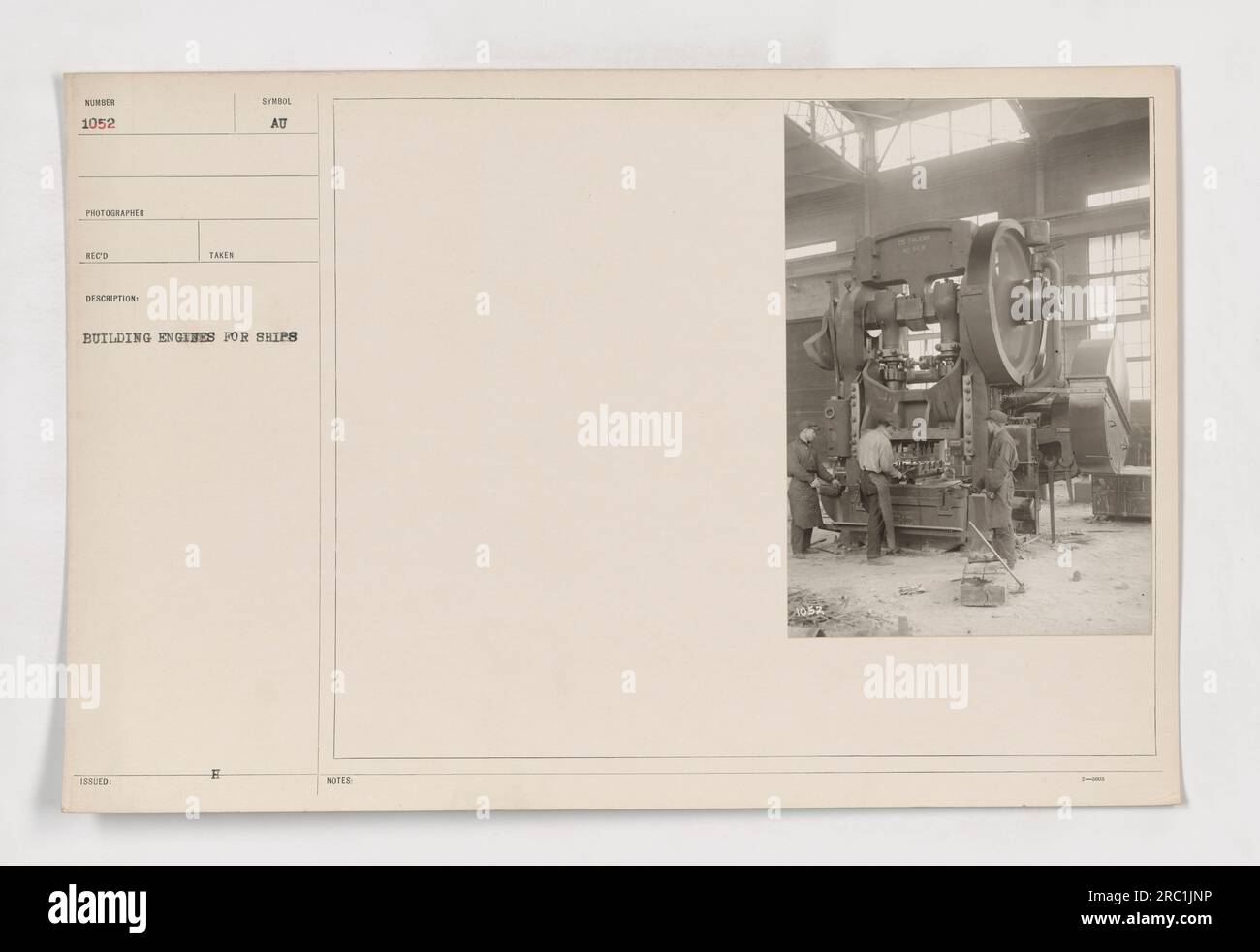 Workers constructing ship engines in a shipbuilding facility during ...