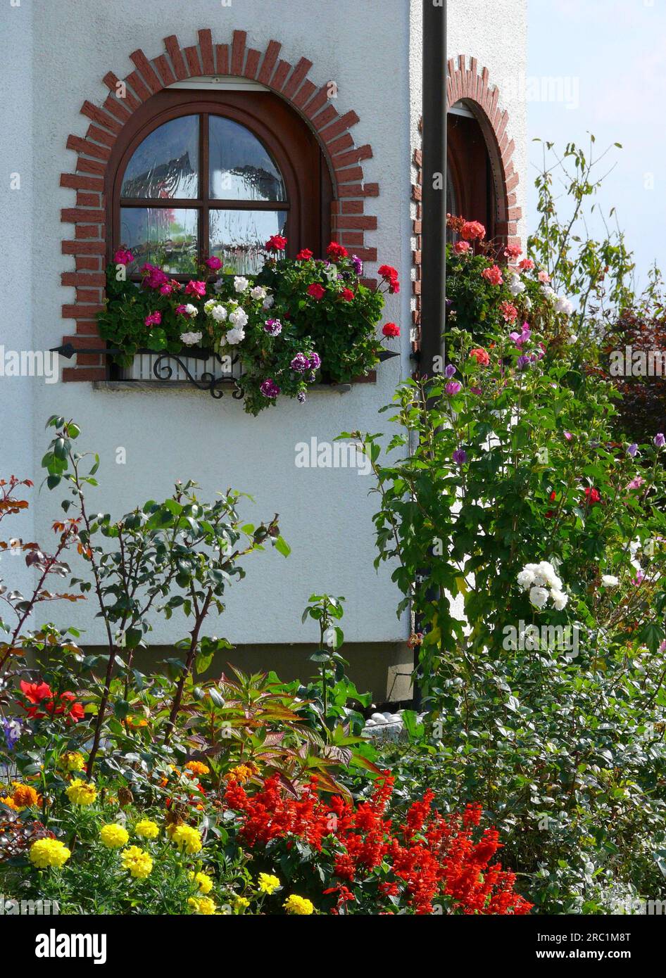 House, arched window with flowers and garden Stock Photo - Alamy