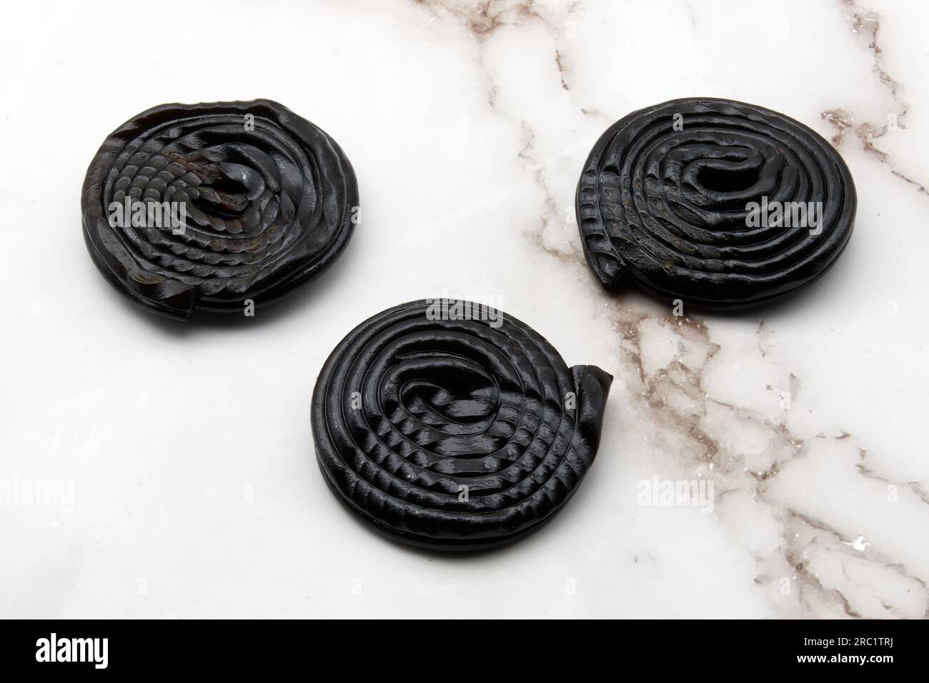 Tasty black licorice candies on white marble background Stock Photo - Alamy