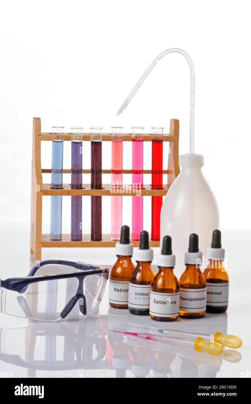 Rack with test tubes with coloured substances, glasses, plastic bottle ...