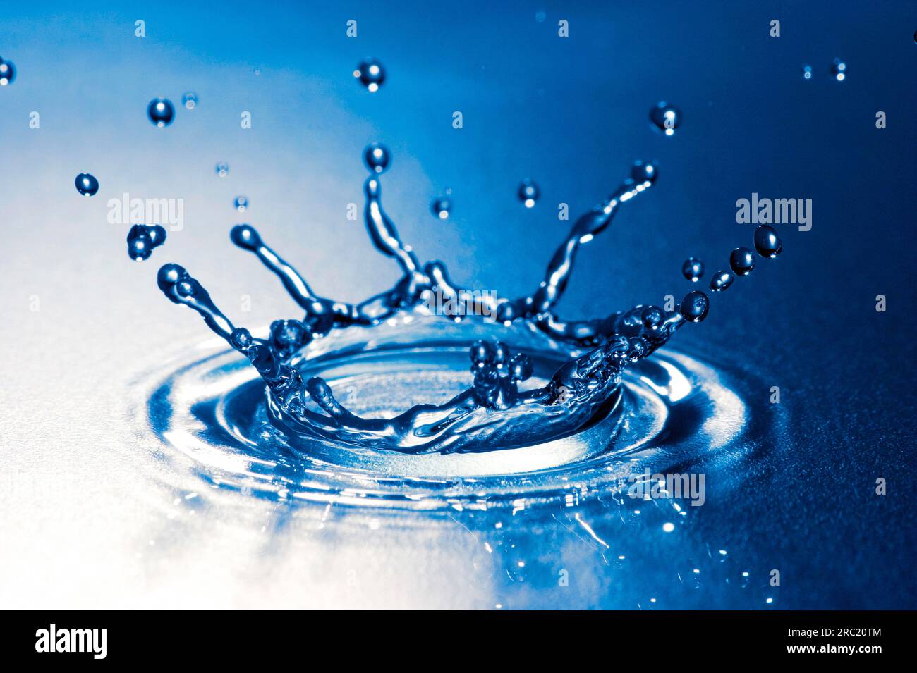 Falling water drop, bursts on surface Stock Photo - Alamy