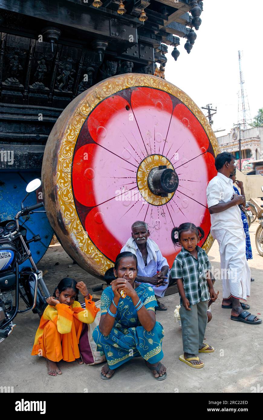 A mother with her children sitting under Vedagiriswarar Temple chariot ...