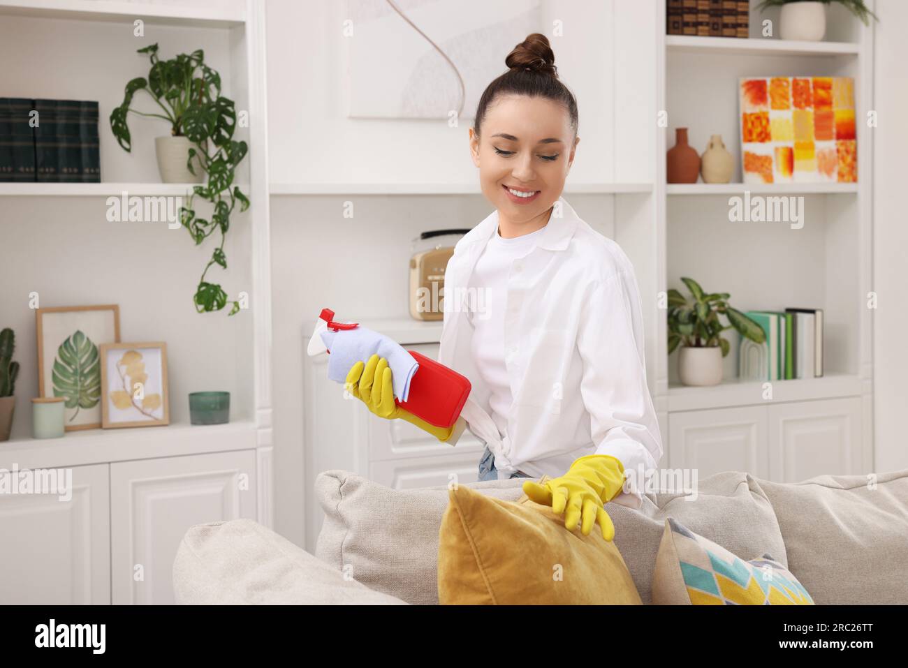 Spring cleaning. Young woman tidying up room at home Stock Photo - Alamy