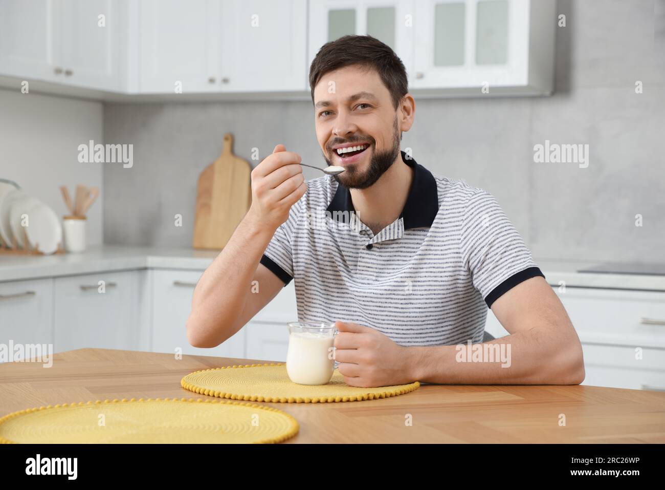 Man eating yogurt in kitchen hi-res stock photography and images - Alamy