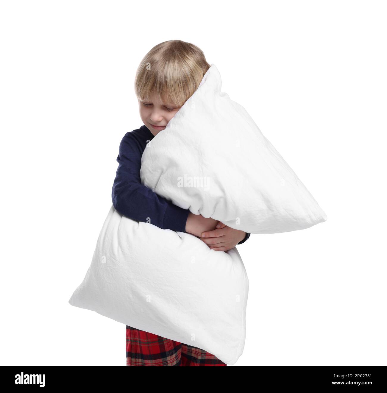 Boy in pajamas hugging pillow on white background Stock Photo - Alamy