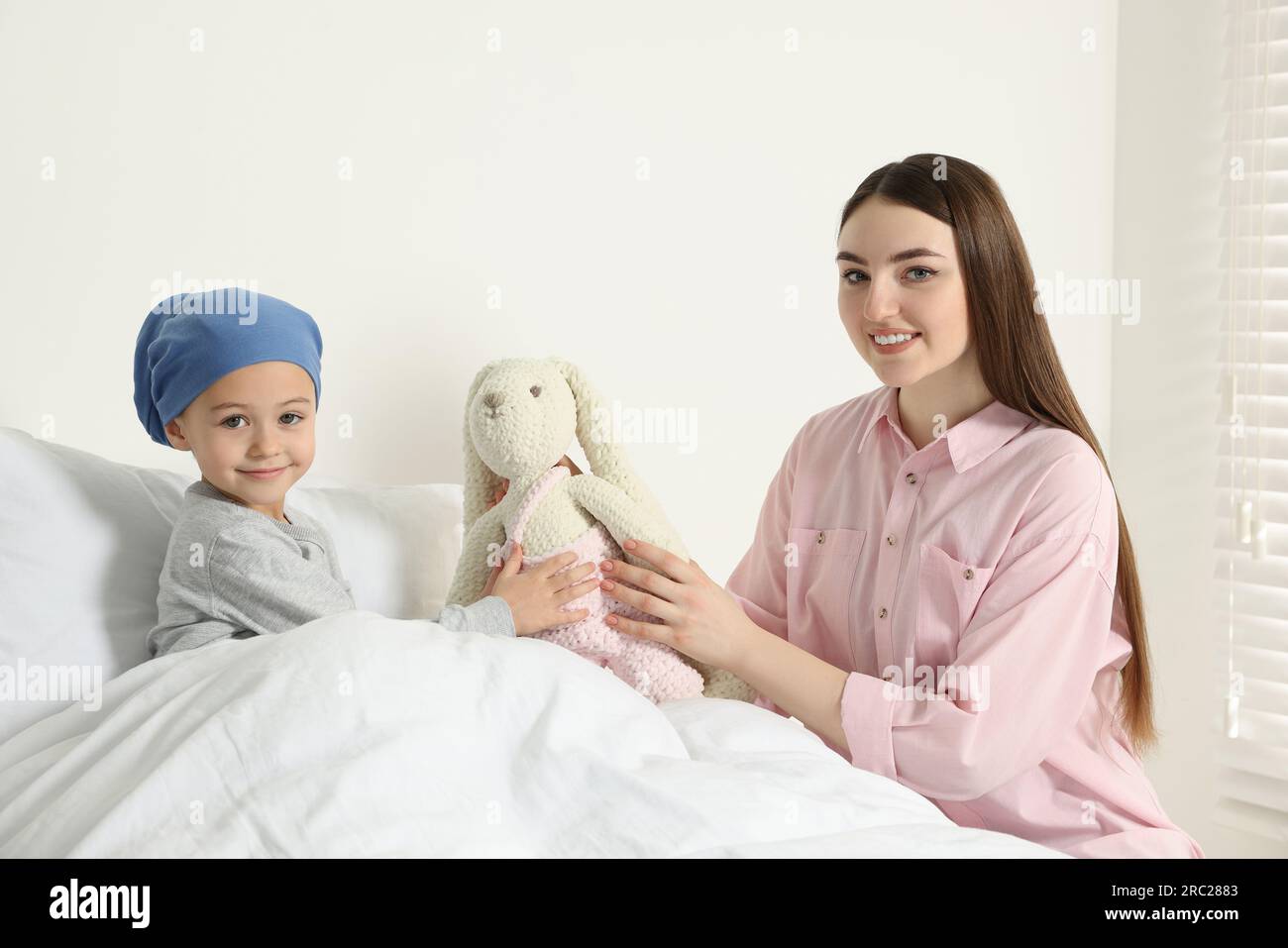 Childhood cancer. Mother and daughter with toy bunny in hospital Stock ...