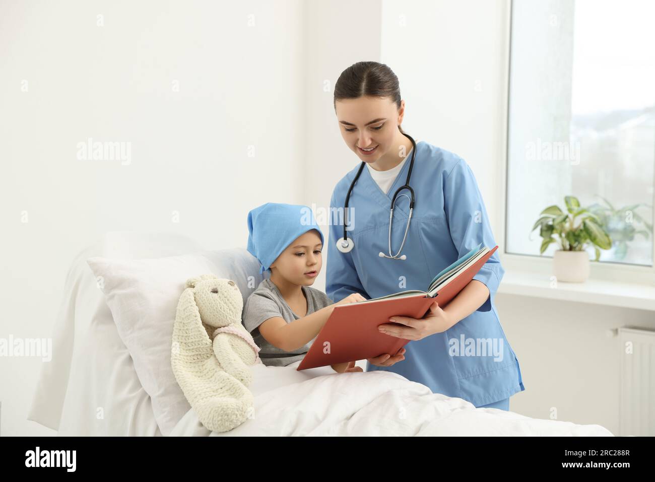 Childhood cancer. Doctor and patient reading book in hospital Stock ...