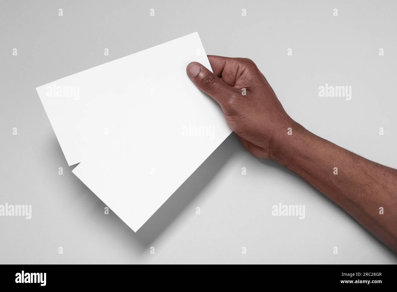 African American man holding flyers on white background, closeup ...