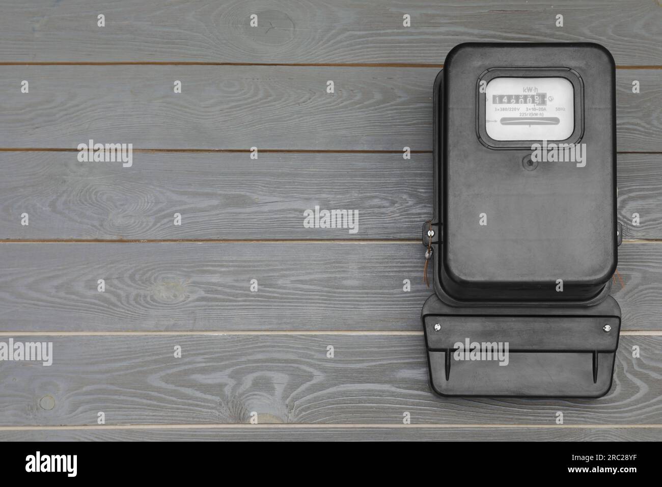Black electric meter on grey wooden background, top view with space for ...