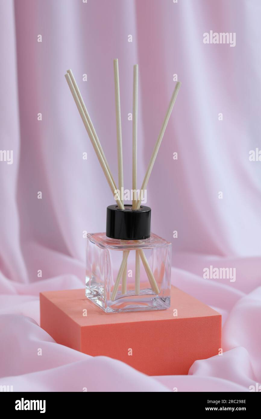 Stylish presentation of reed diffuser on pink fabric Stock Photo - Alamy