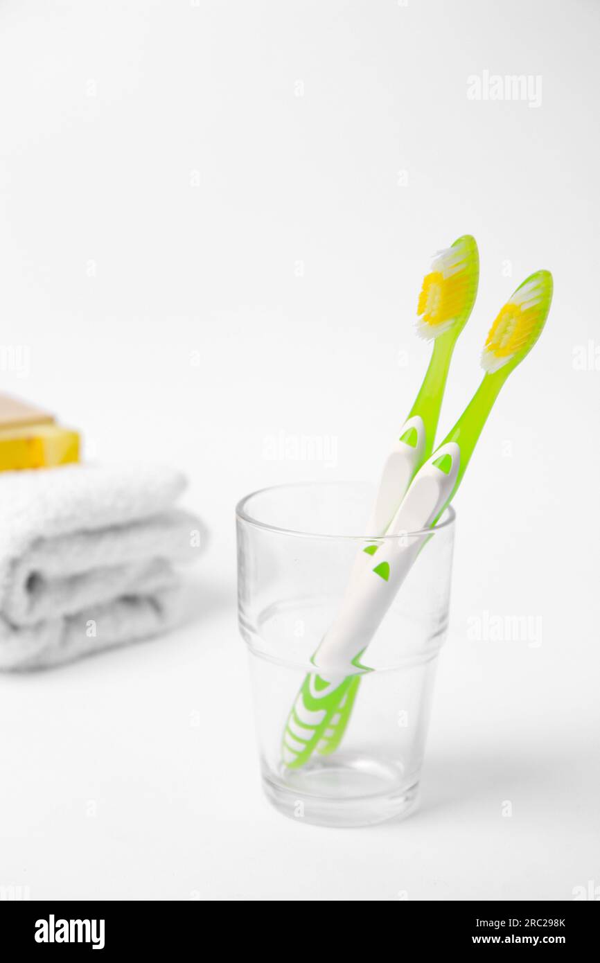 Light green toothbrush in glass holder on white background Stock Photo ...