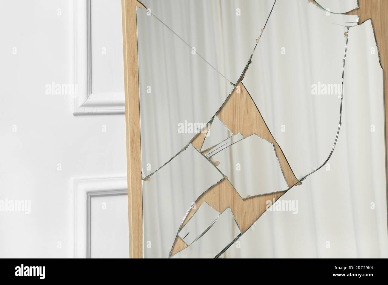 Broken mirror with many cracks near white wall, closeup Stock Photo - Alamy