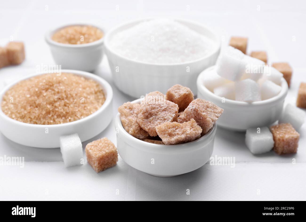 Different types of sugar on white table, closeup Stock Photo - Alamy