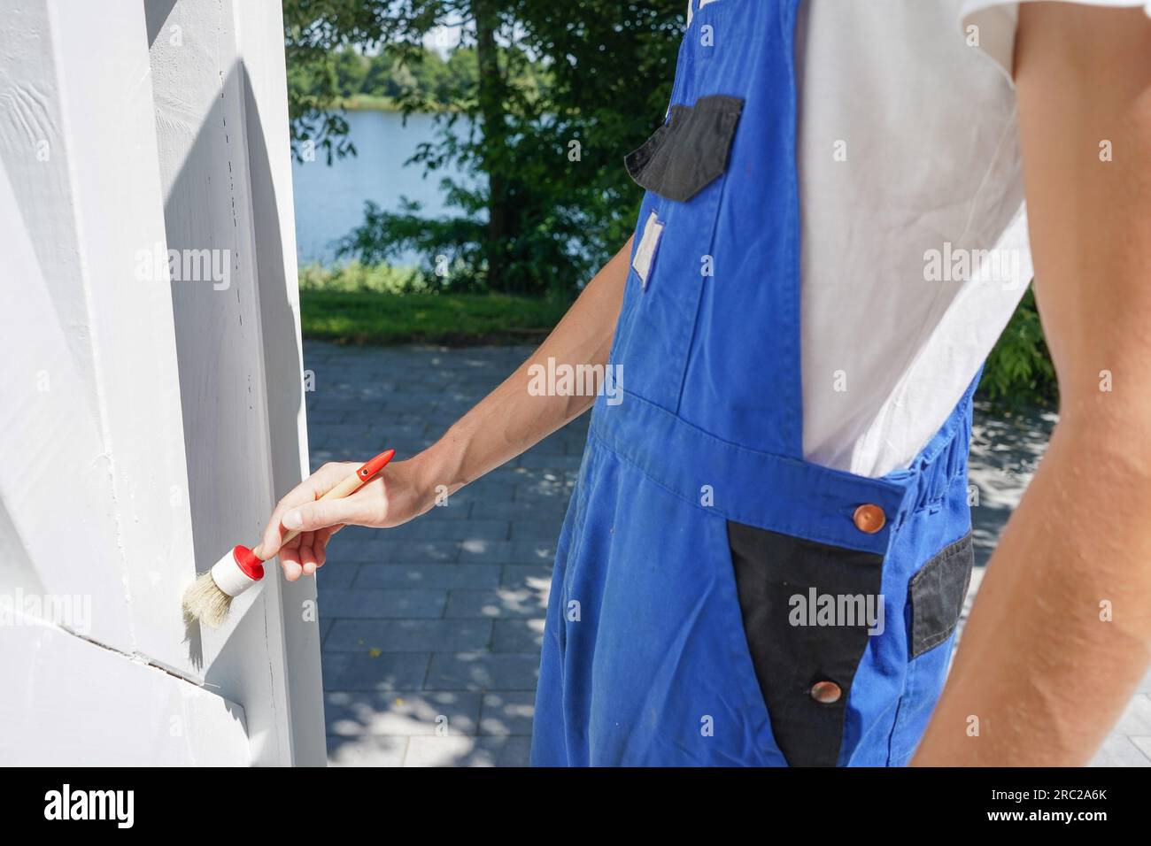 Worker painting white wood. Painter at work. Worker in boiler suit ...