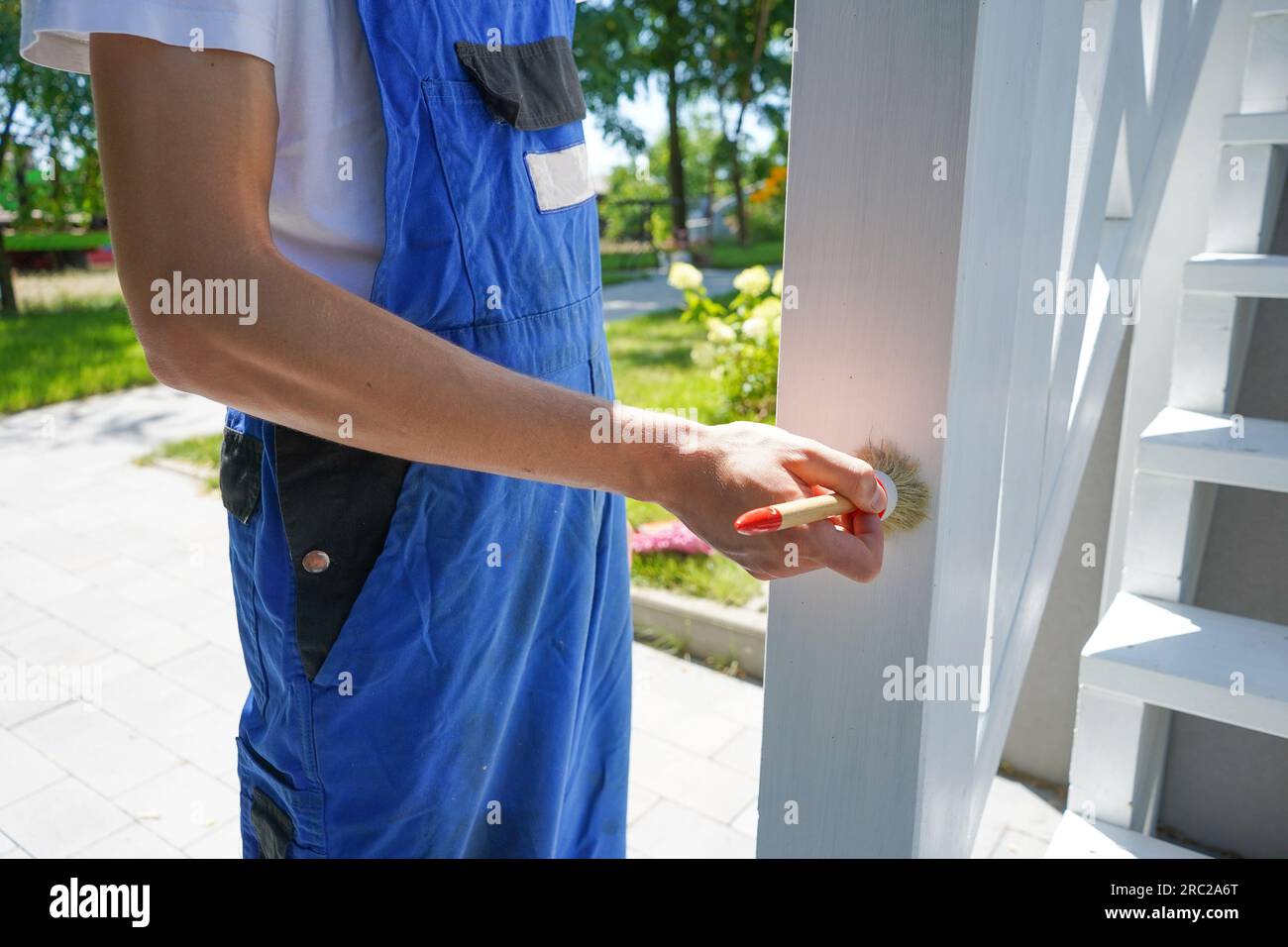 Worker painting white wood. Painter at work. Worker in boiler suit ...