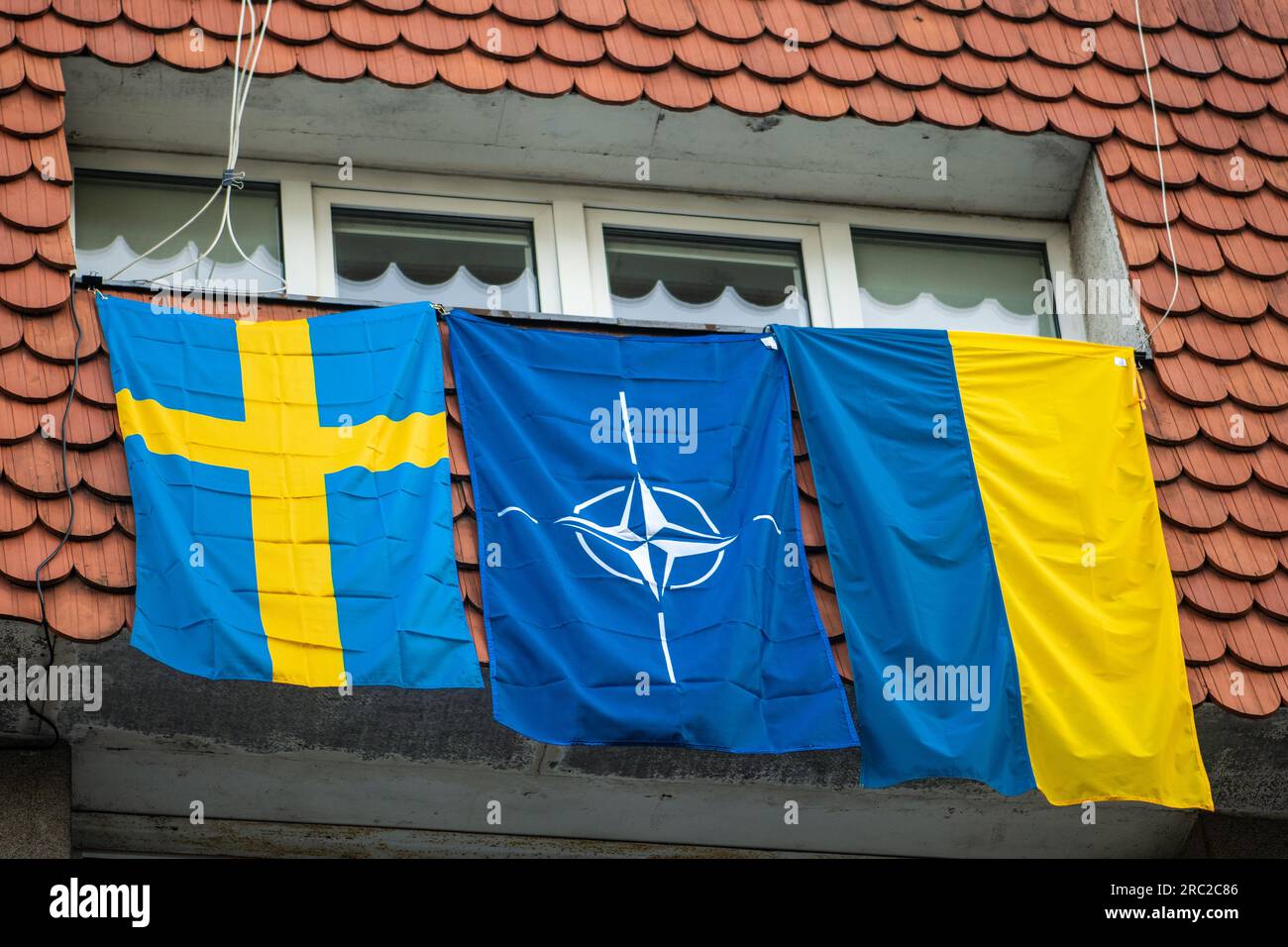 Flags of NATO, Sweden and Ukraine waving on the window during Nato ...