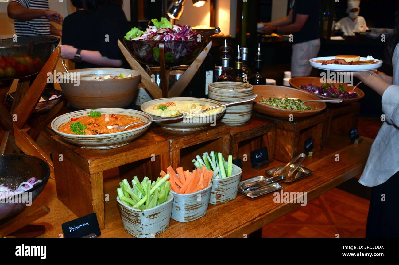 A person chooses food from part of the breakfast buffet at the Grand ...