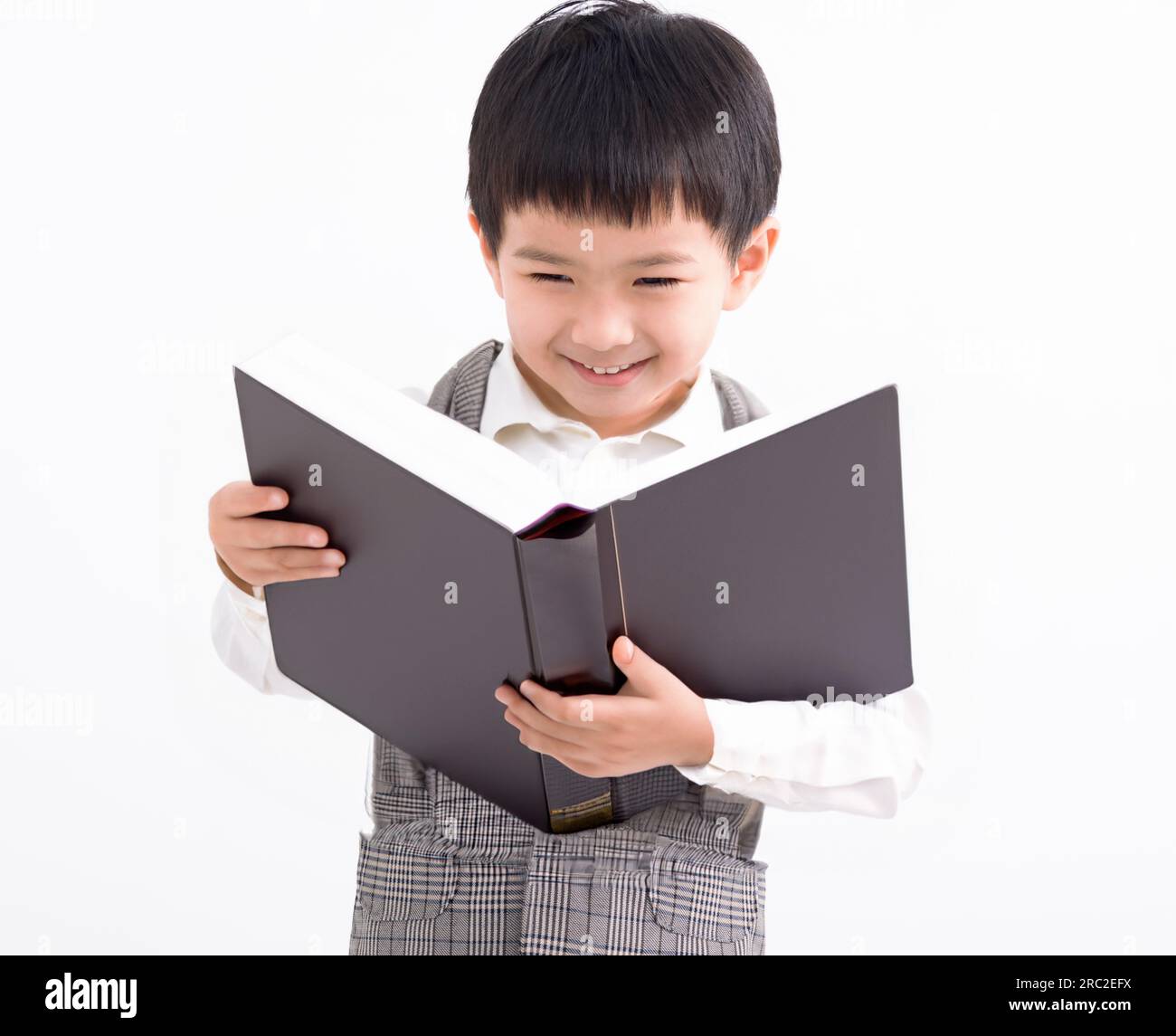 Happy kid holding and studying book Stock Photo - Alamy