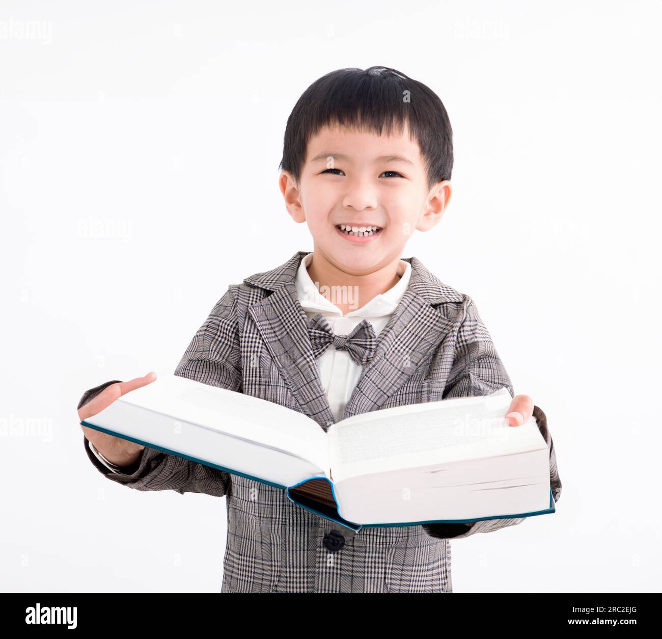 Happy kid holding and studying book Stock Photo - Alamy