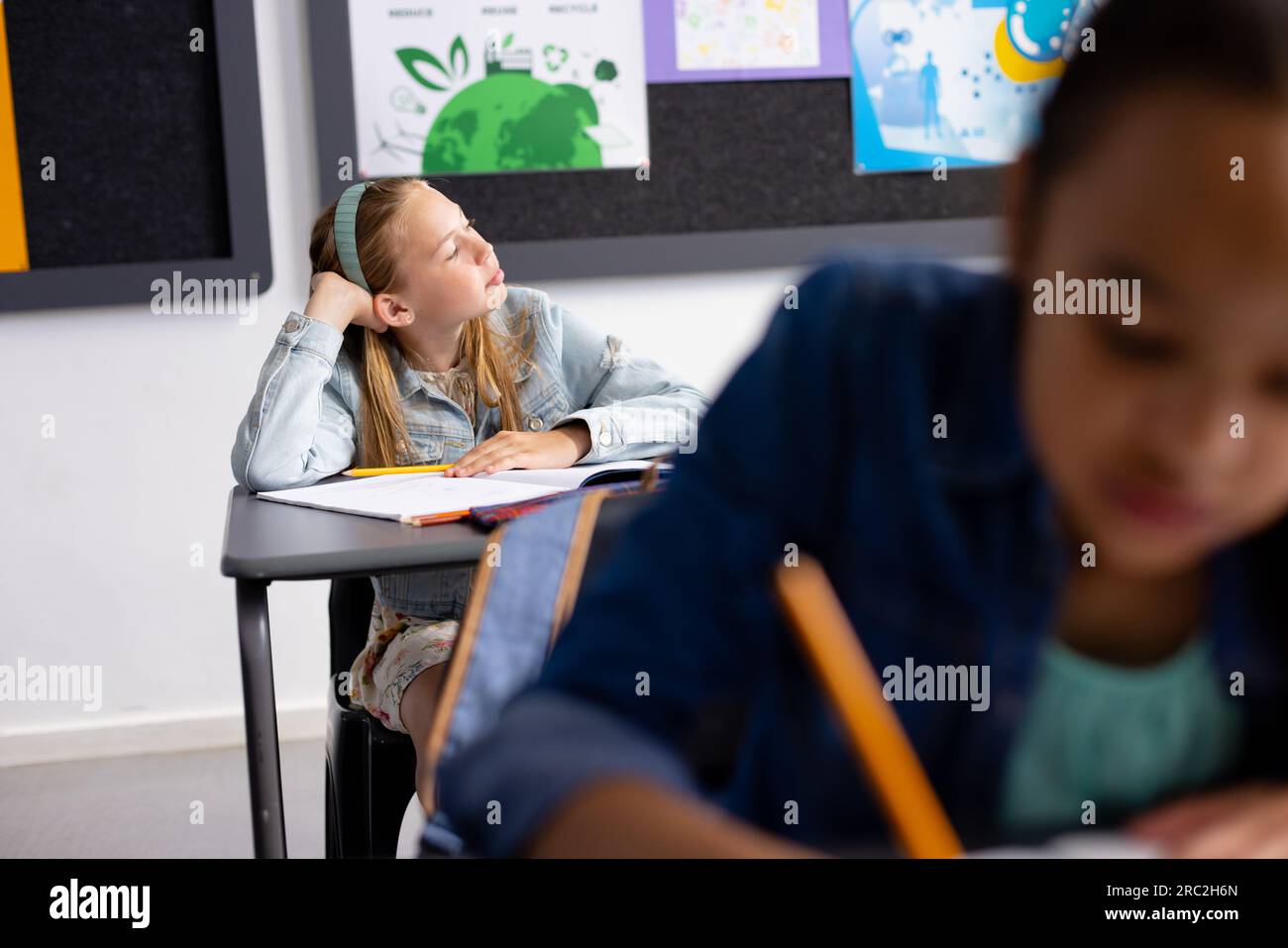 Happy diverse schoolchildren sitting at desks in school classroom Stock ...