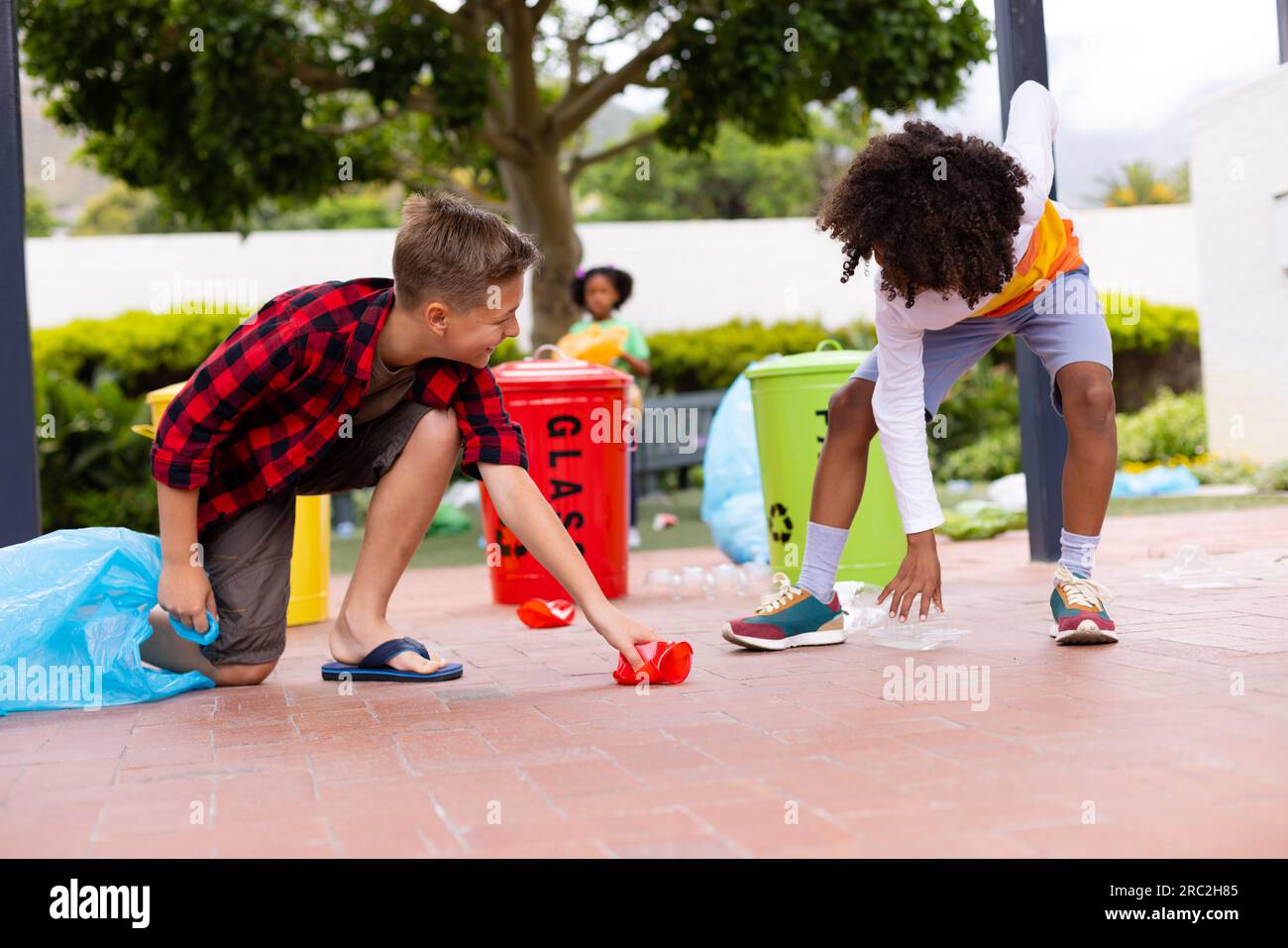 Happy diverse schoolchildren cleaning and recycling waste at school ...