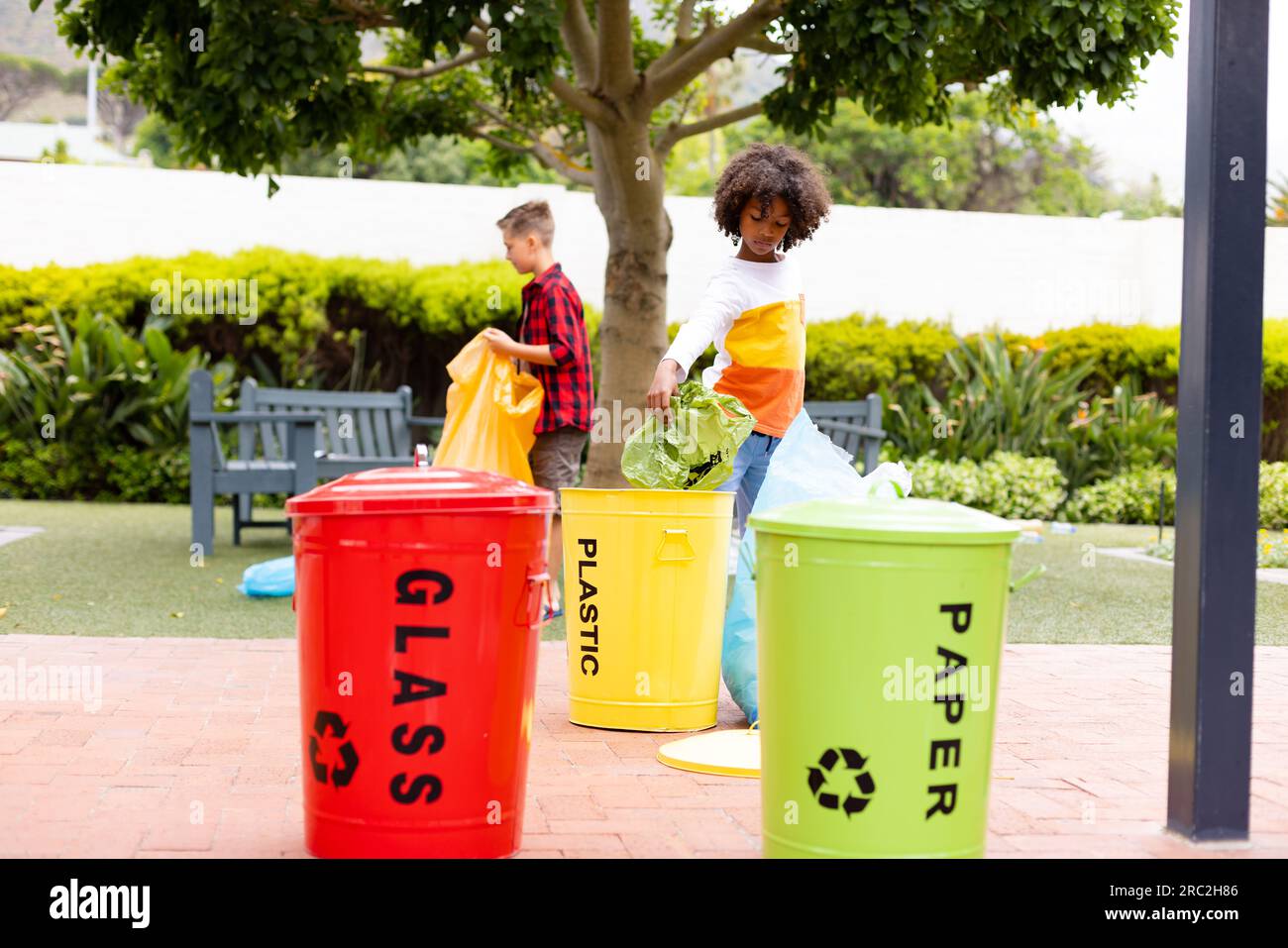 Happy diverse schoolchildren cleaning and recycling waste at school ...
