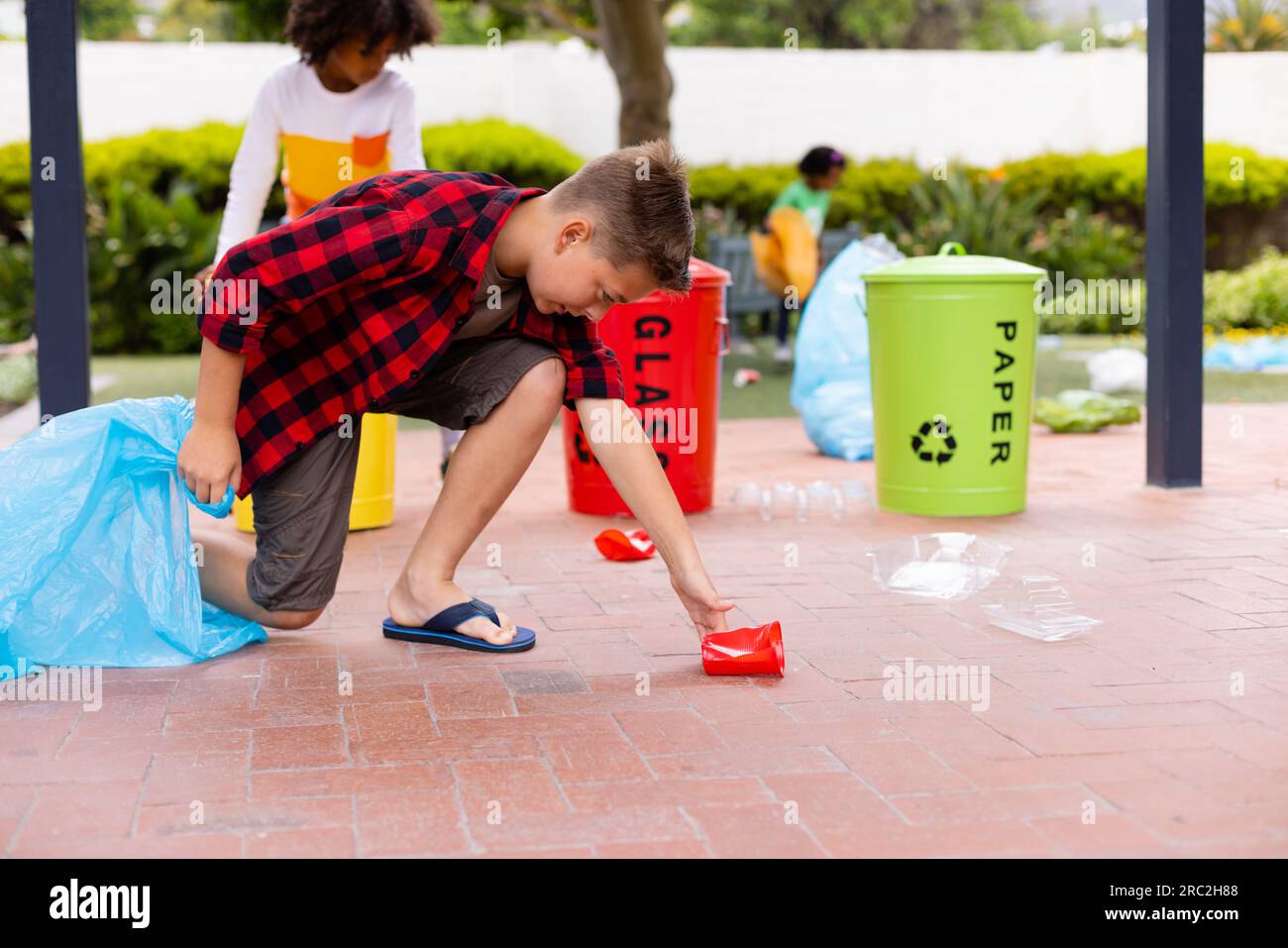 Happy diverse schoolchildren cleaning and recycling waste at school ...