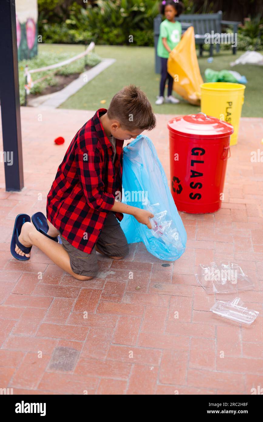 Happy diverse schoolchildren cleaning and recycling waste at school ...