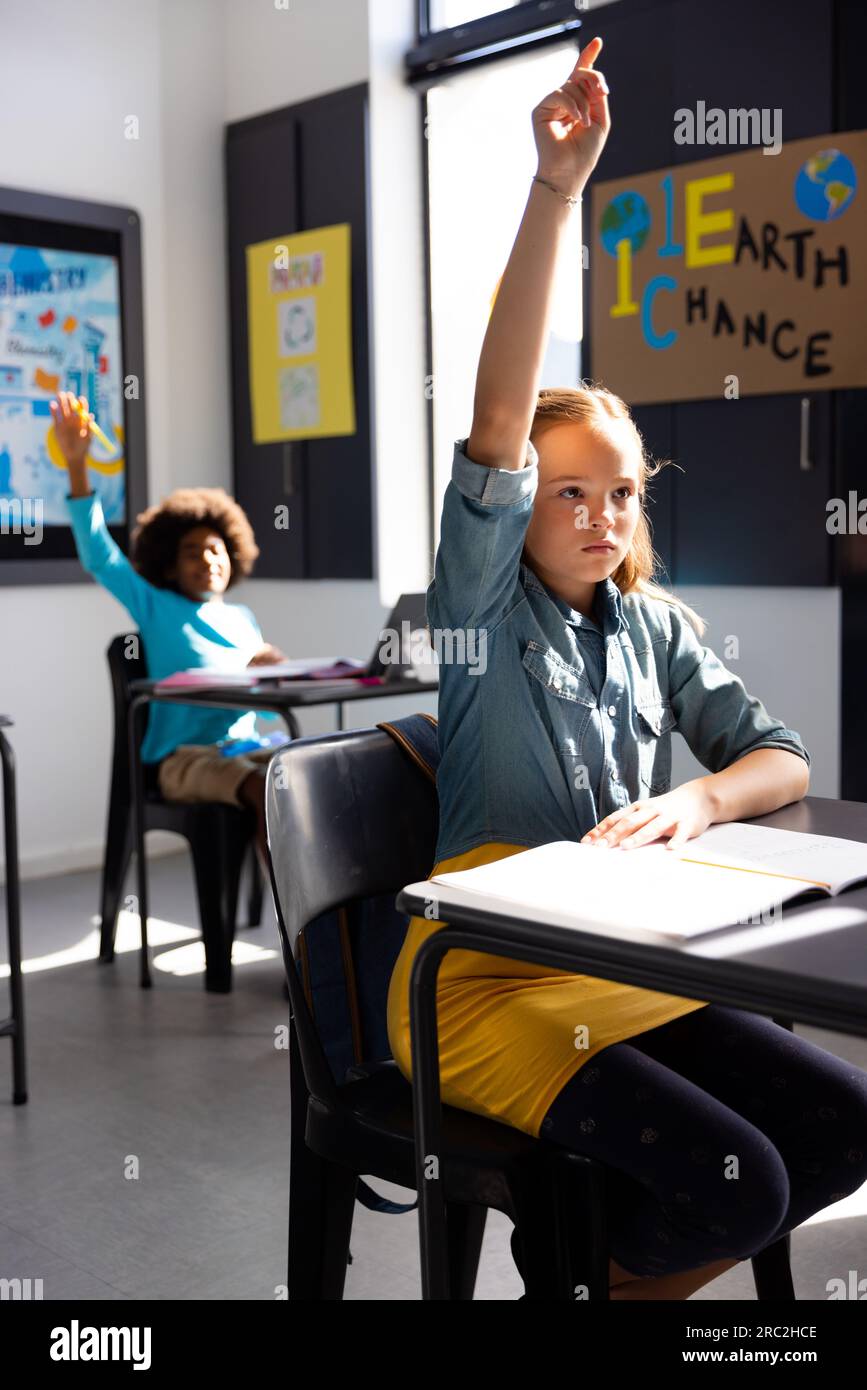 Happy diverse schoolchildren sitting at desks in school classroom Stock ...