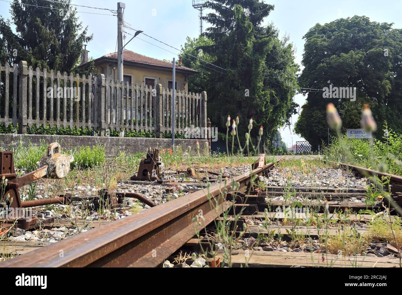 Abandoned railroad crossing in a grove on a sunny day in the italian ...