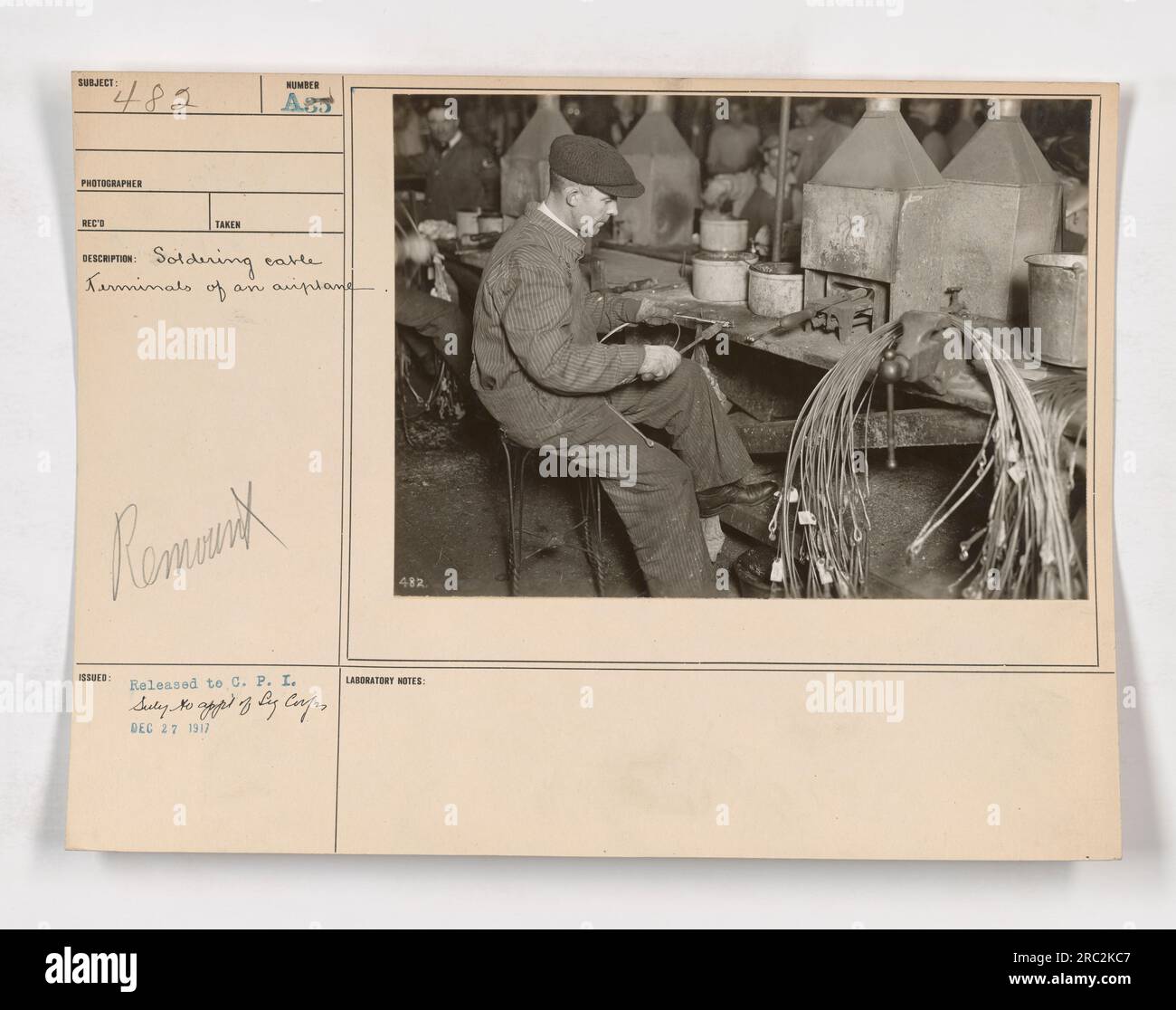 A soldier is shown soldering cable terminals in the process of airplane ...