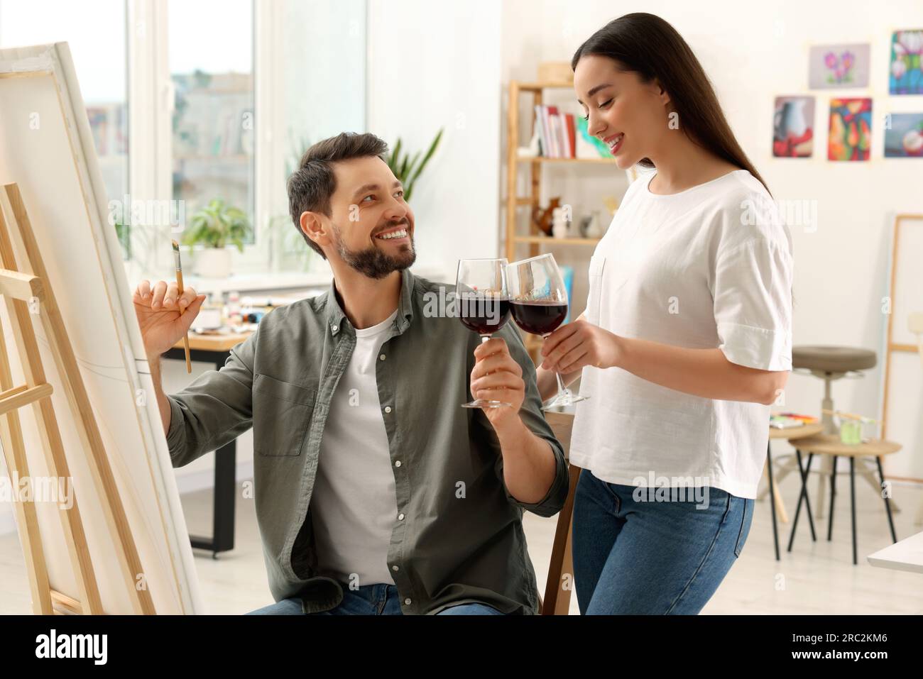 Artist and her student drinking wine during painting class in studio ...