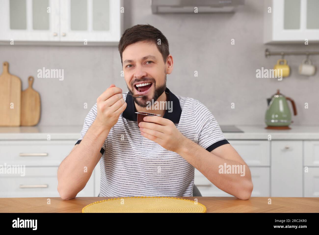 Man eating yogurt in kitchen hi-res stock photography and images - Alamy