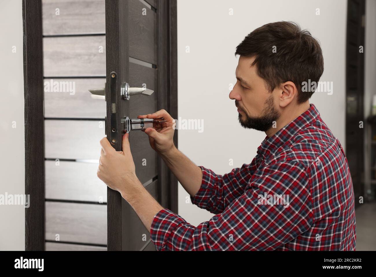Handyman changing core of door lock indoors Stock Photo - Alamy