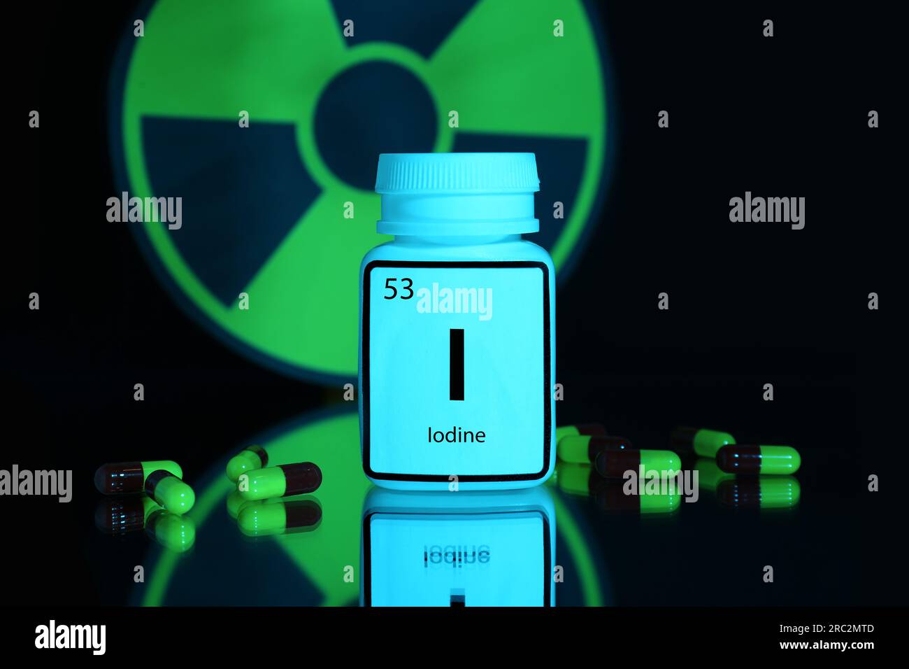 Bottle of medical iodine, pills and radiation sign on black background ...