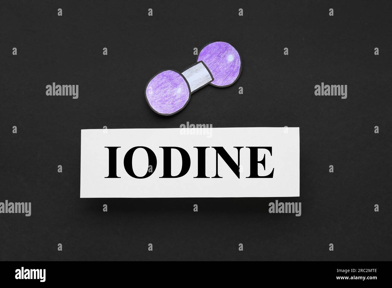 Card with word Iodine and atom shape made of paper on black background ...