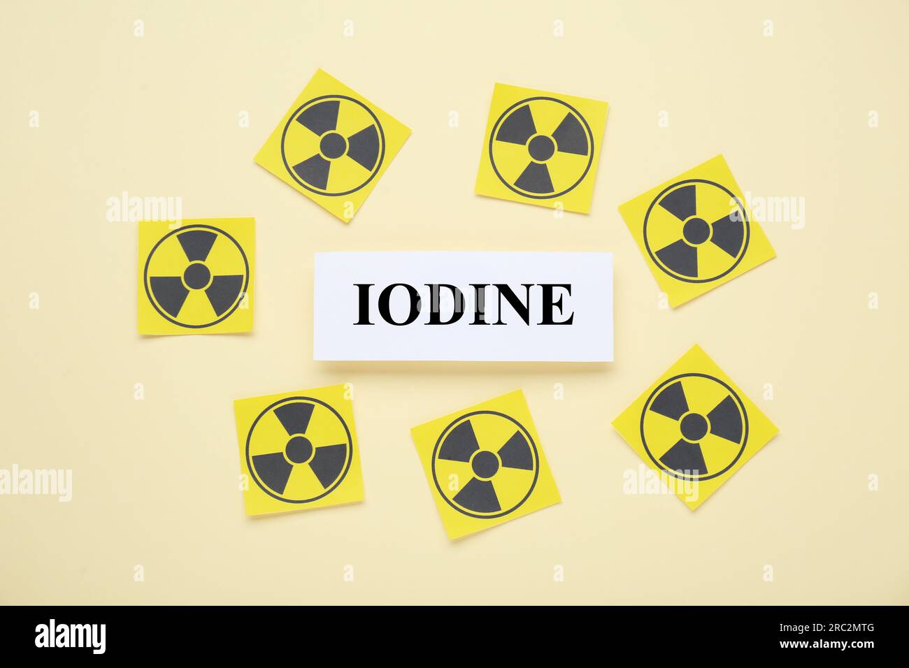 Paper note with word Iodine and radiation signs on beige background ...