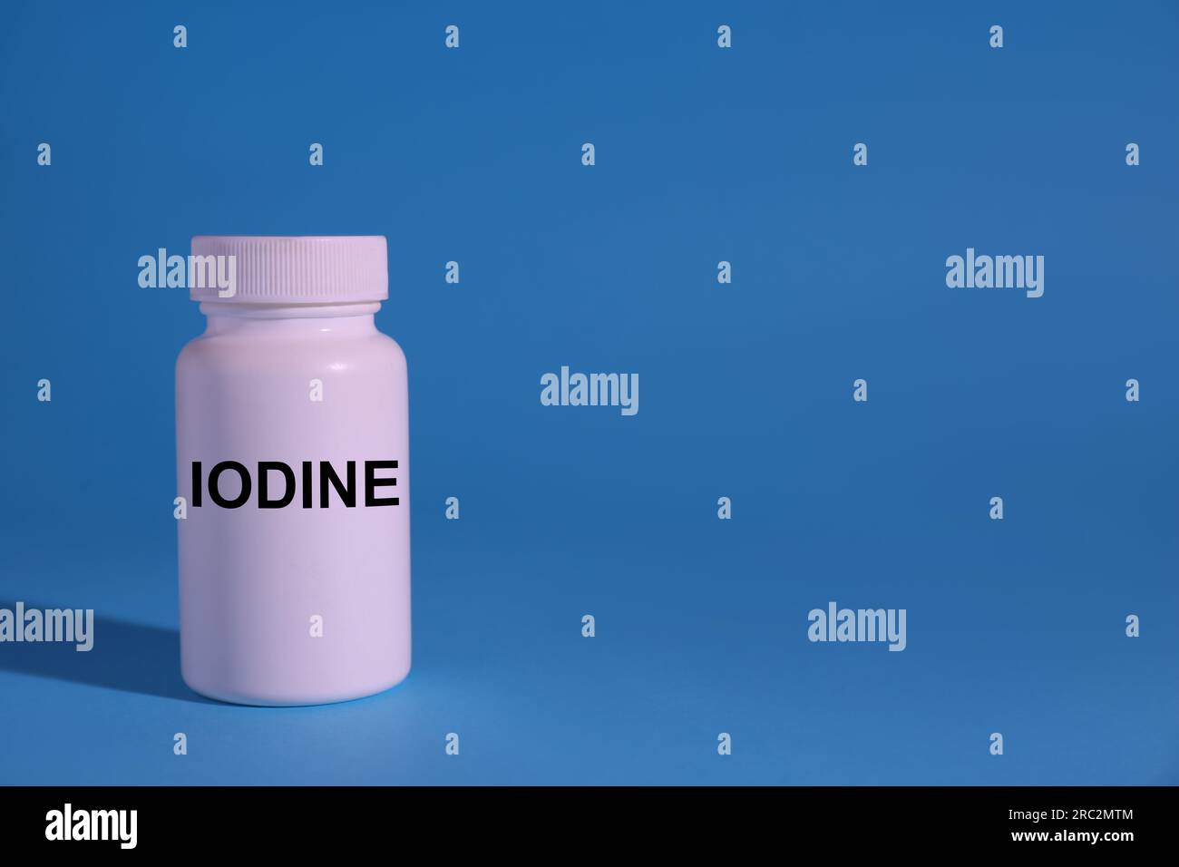 Plastic container of medical iodine on light blue background, space for ...