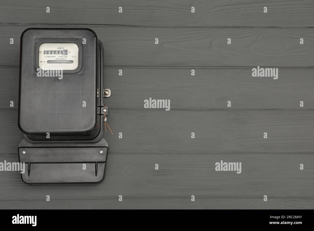 Black electric meter on grey wooden background, top view with space for ...