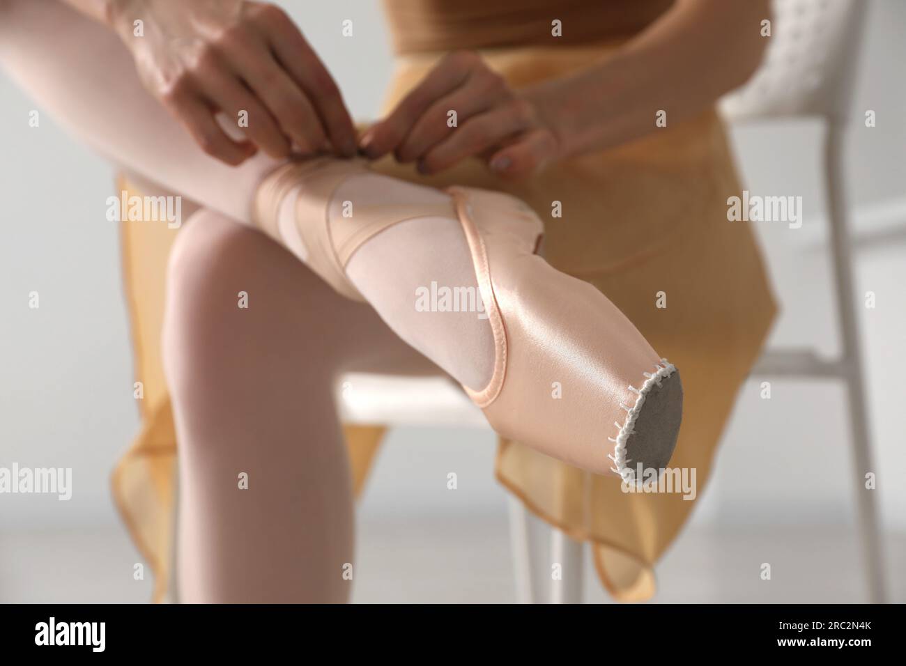 Ballerina tying pointe shoes in dance studio, closeup Stock Photo - Alamy