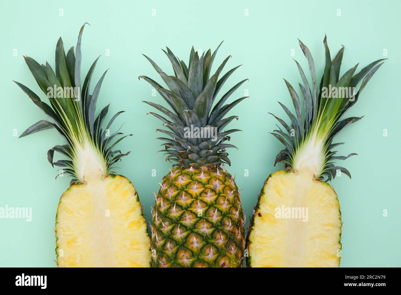 Whole and cut ripe pineapples on light green background, flat lay Stock ...
