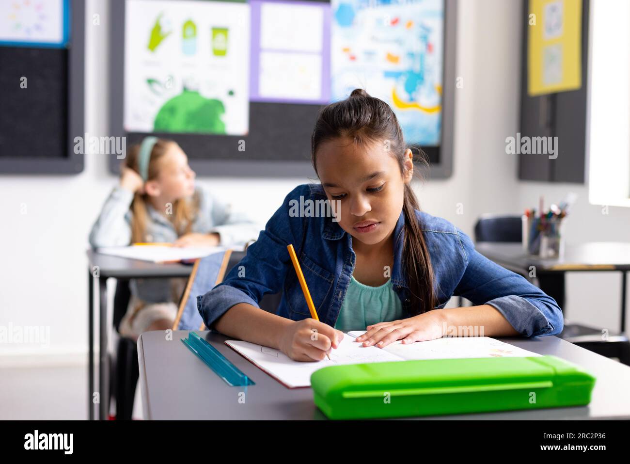 Happy diverse schoolchildren sitting at desks in school classroom Stock ...