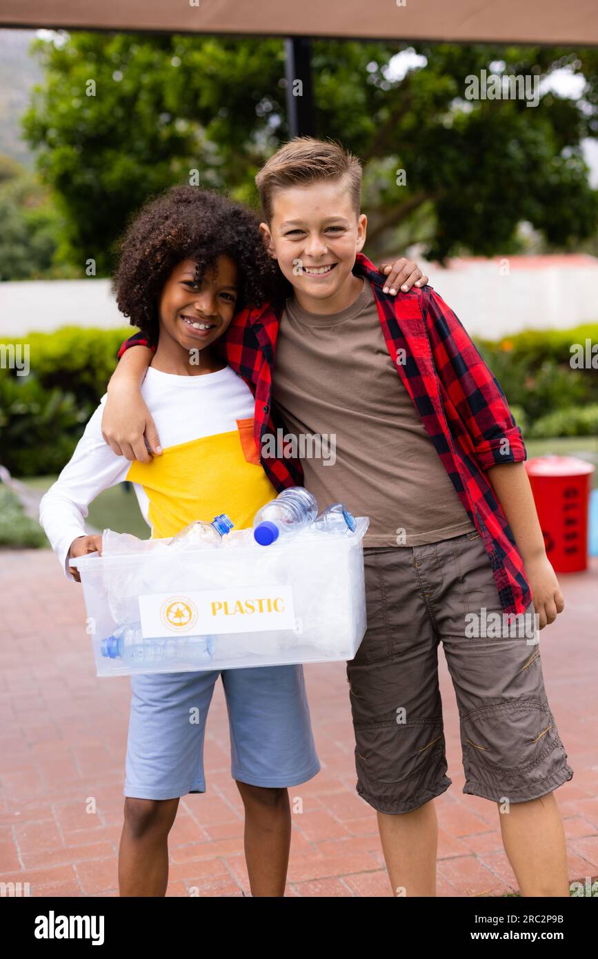 Portrait of happy diverse schoolboys cleaning and recycling waste at ...