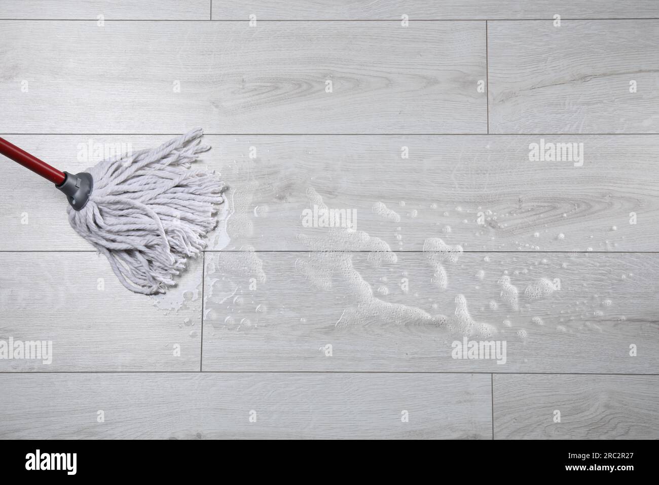 Cleaning wooden floor with mop, above view. Space for text Stock Photo ...
