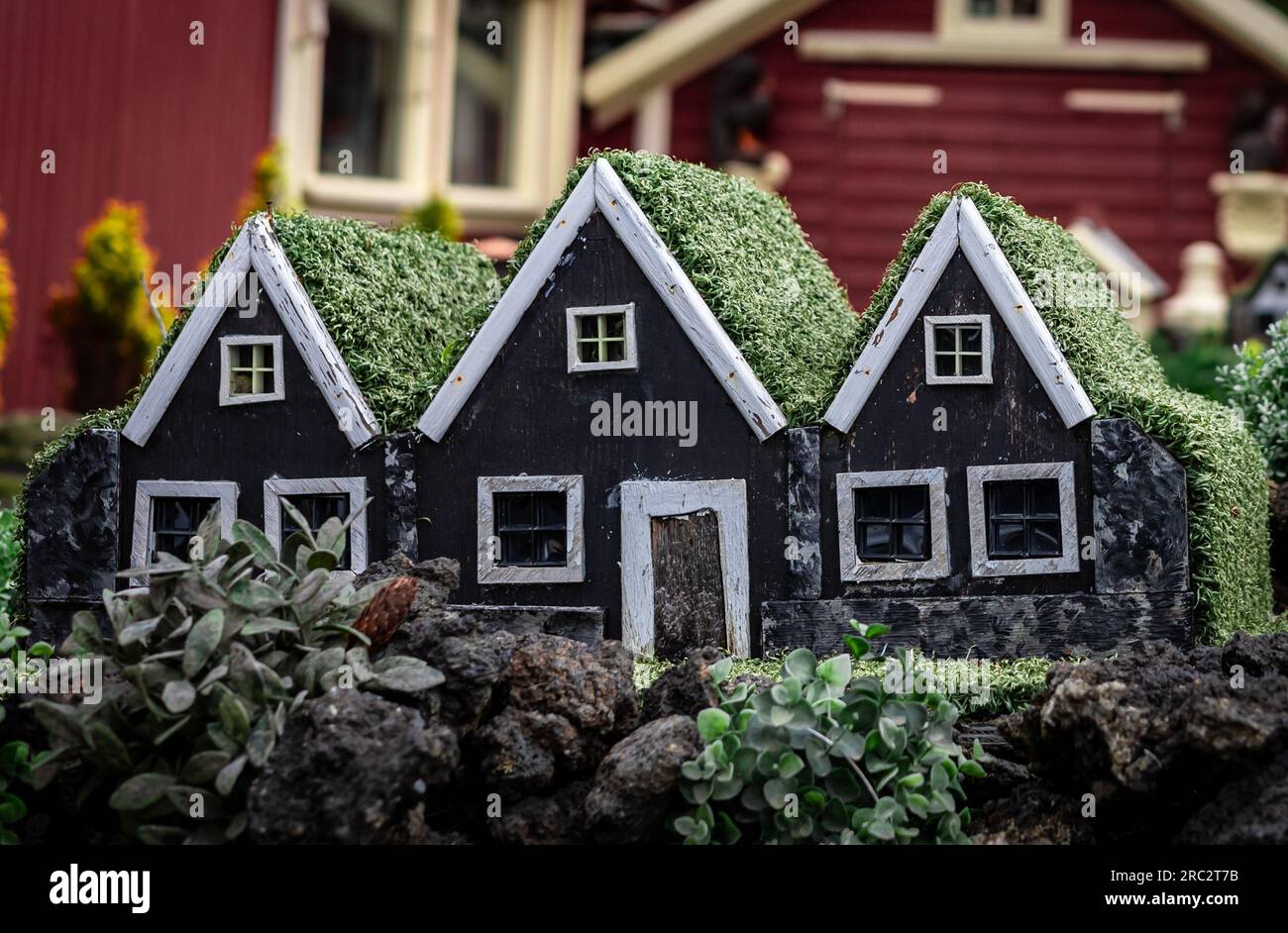 Three small black wooden elf houses with green moss roof, typical for ...