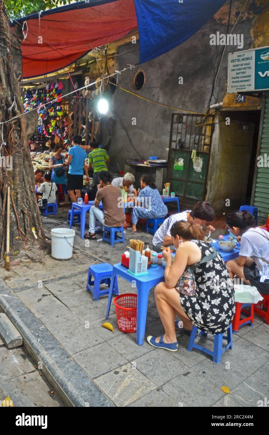 A tourist eats pho at a streetside stall in Hanoi, Vietnam Stock Photo ...